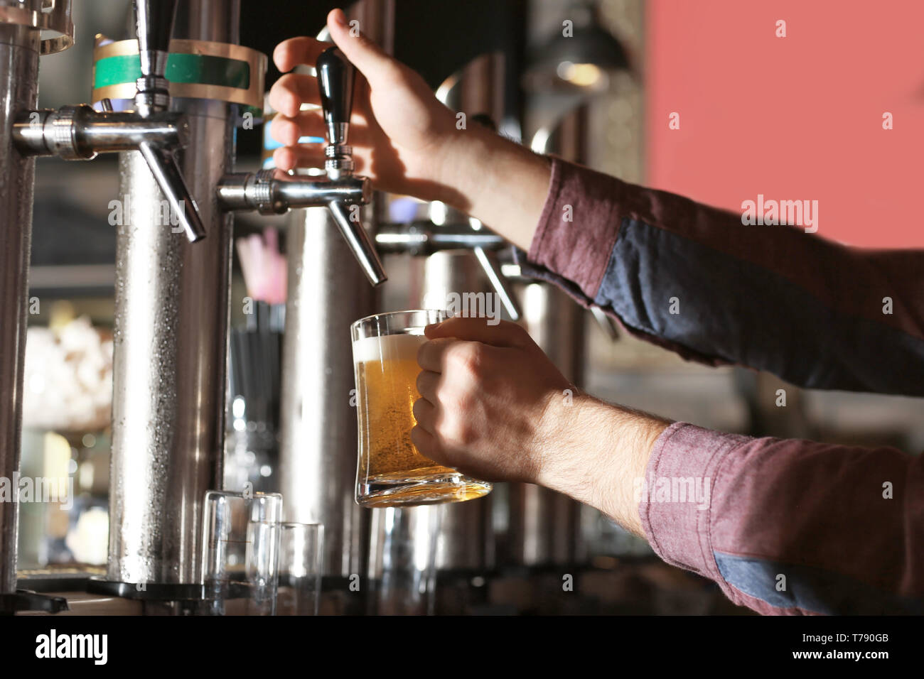 Bartender pouring beer into glass in bar Stock Photo - Alamy