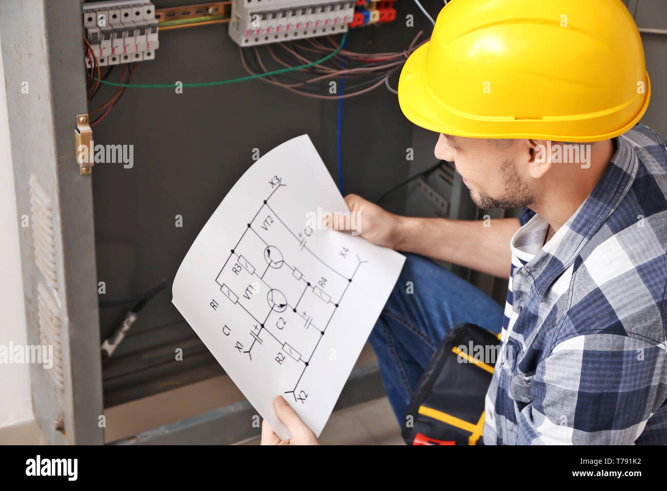 Electrician with circuit diagram near distribution board Stock Photo ...