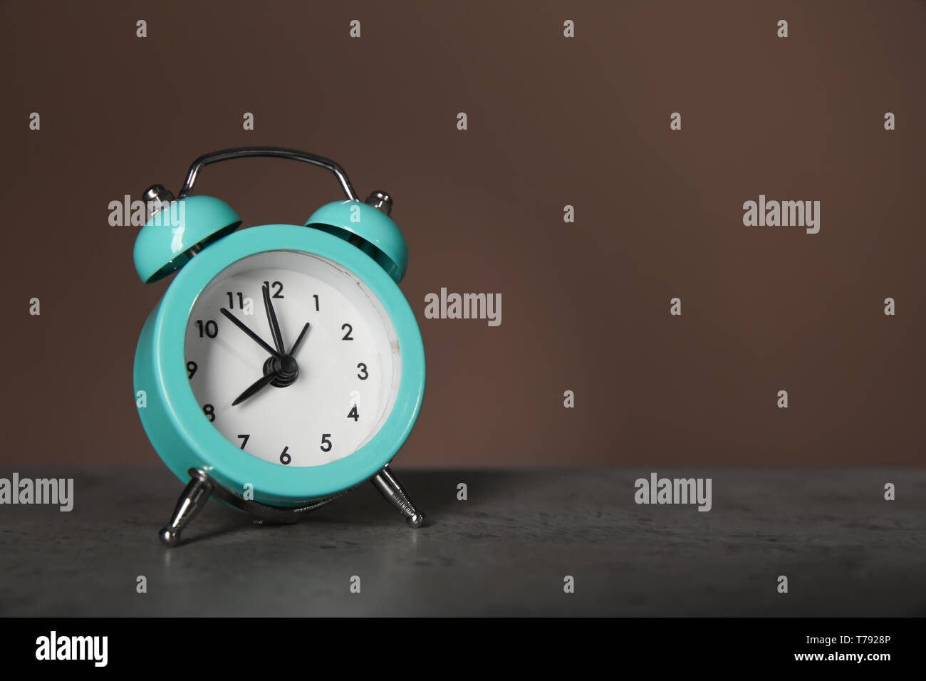 Alarm clock on table against dark color background. Time management ...