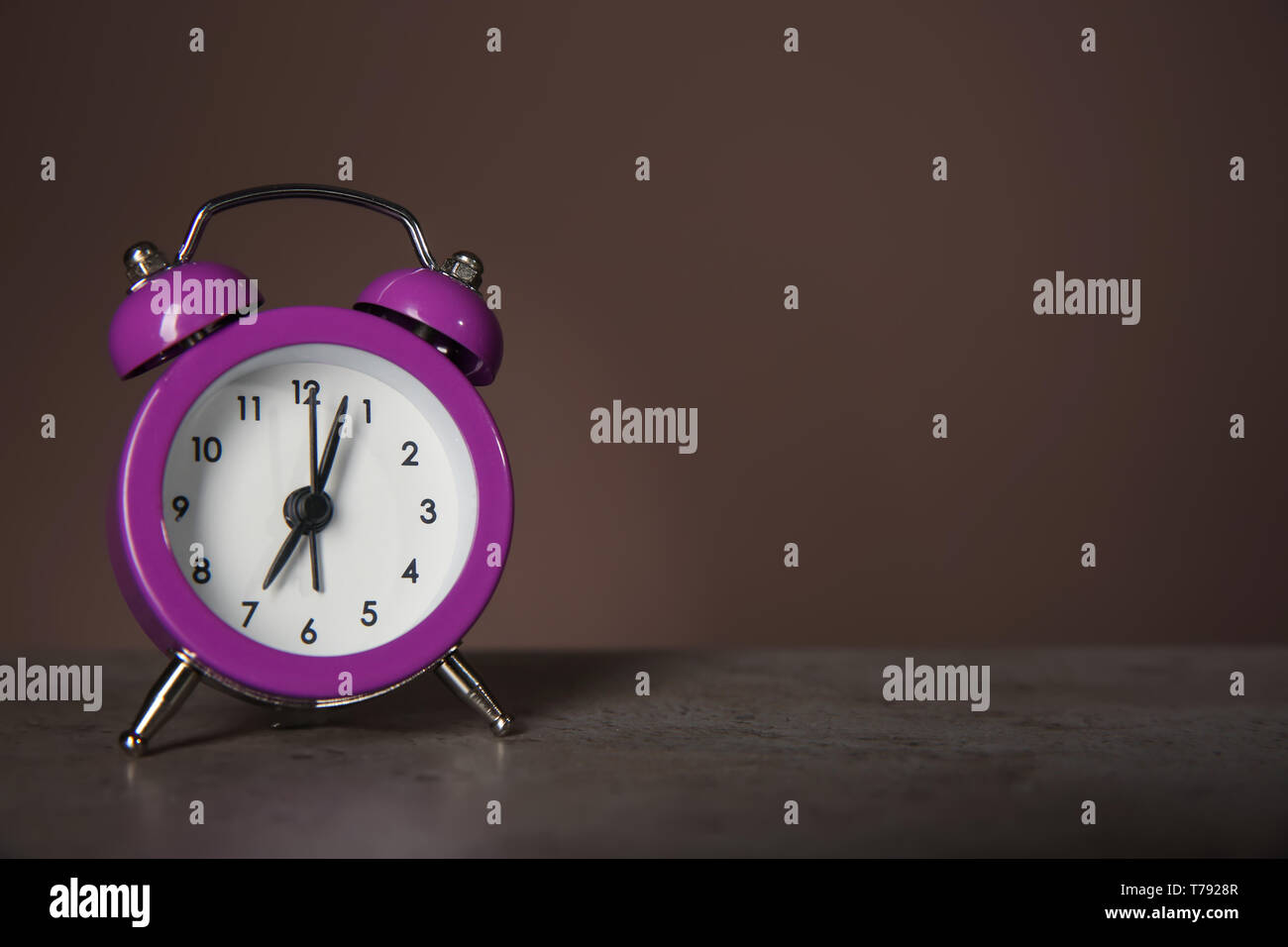 Alarm clock on table against dark color background. Time management ...