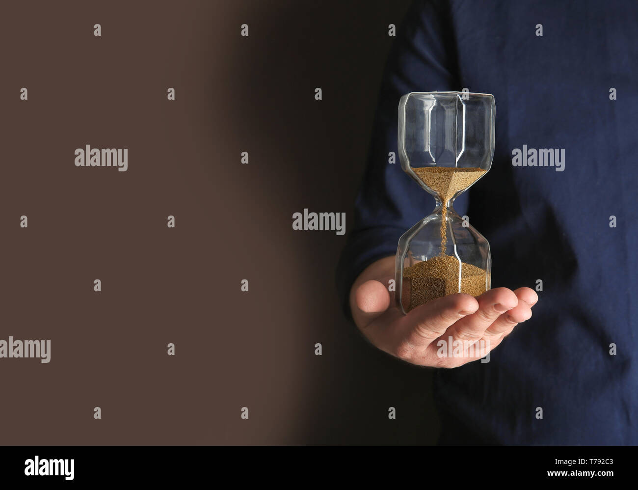 Man holding hourglass on color background. Time management concept ...
