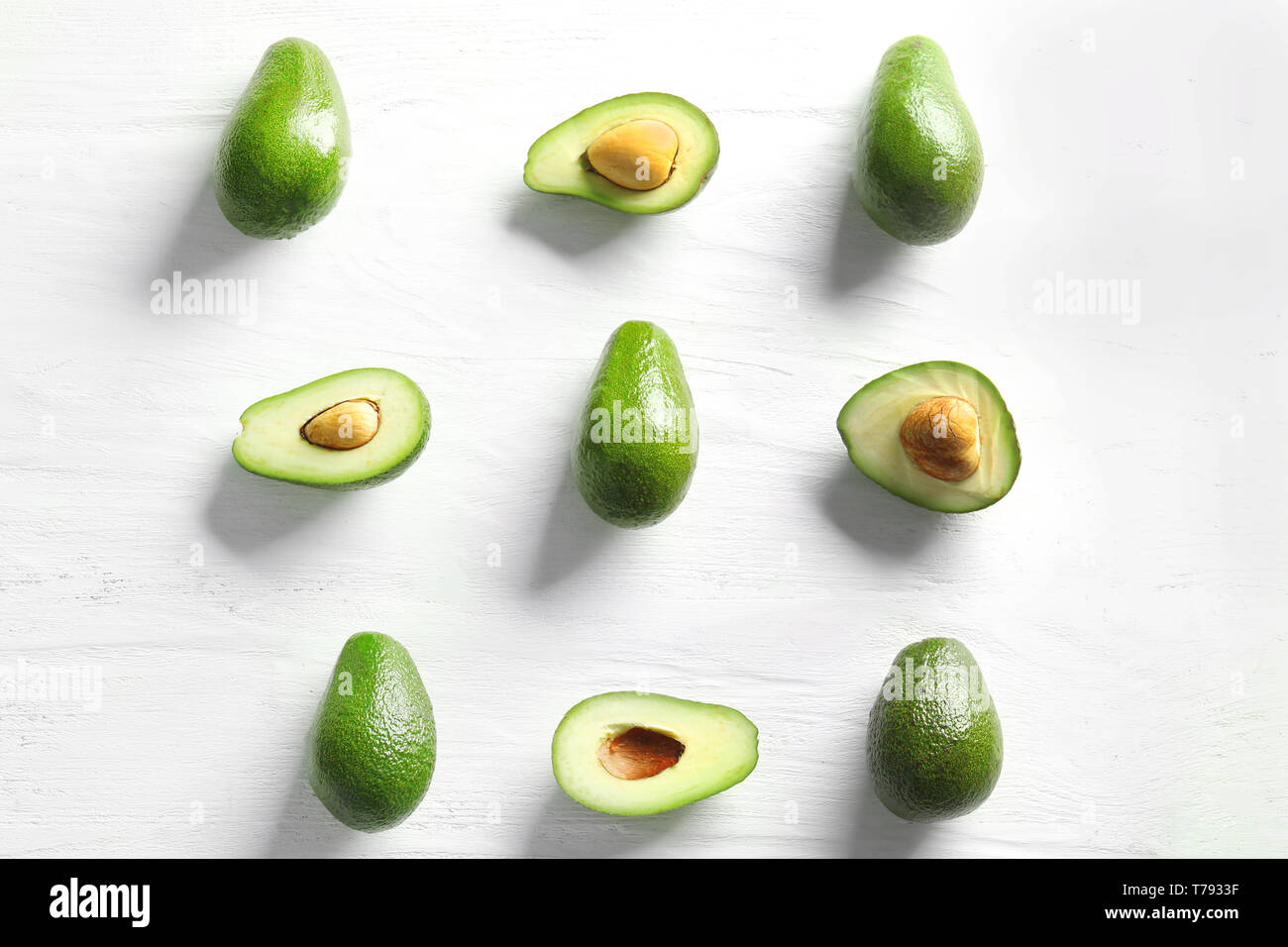 Flat lay composition with ripe avocados on white wooden background ...