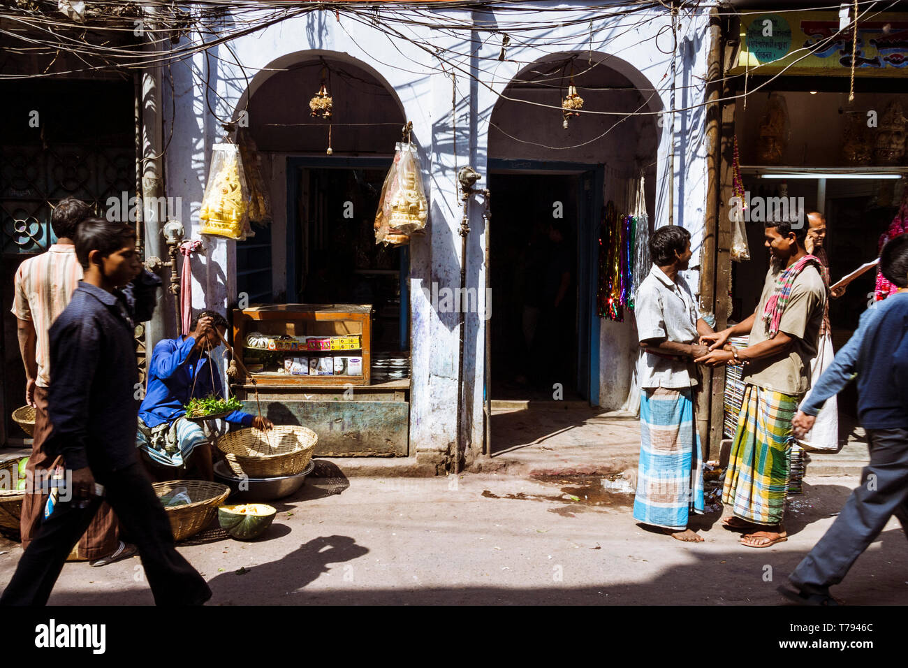 Dhaka, Bangladesh : Two friends chat holding hands at Shankhari Bazaar aka Hindu street one of ...