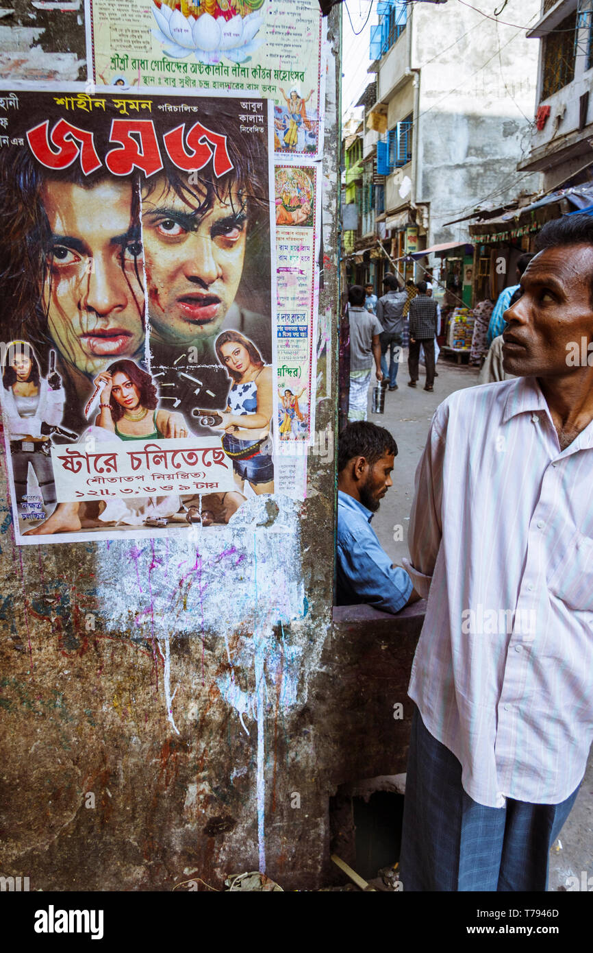 Dhaka, Bangladesh : A man stands by a Dhallywood ( the Bangladeshi film industry) movie poster ...