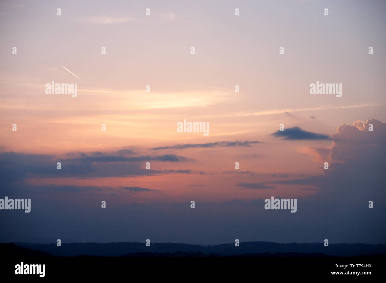 Sunset in the austrian alps with silhouette of colorful clouds in front ...