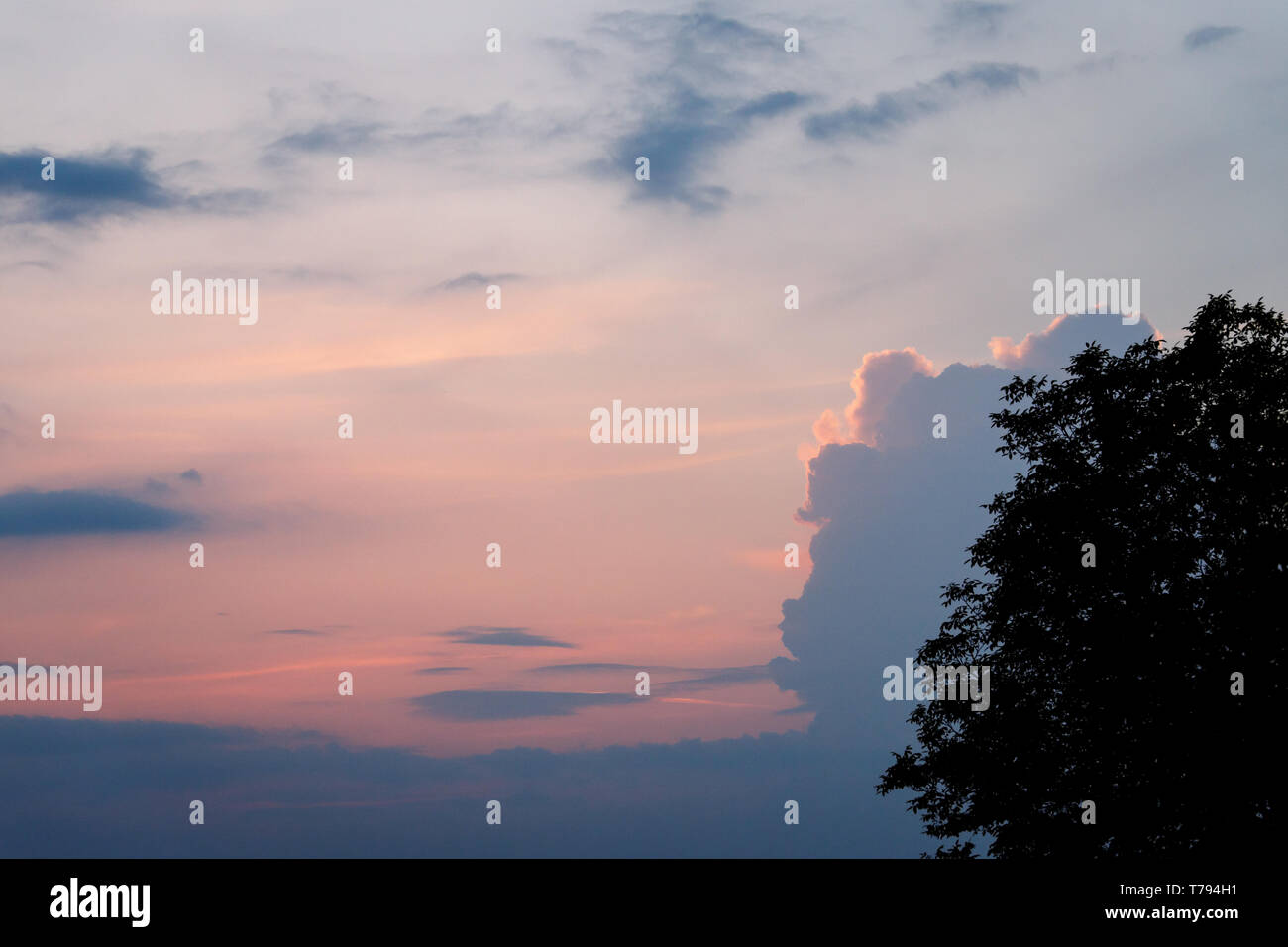 Sunset in the austrian alps with silhouette of colorful clouds in front ...