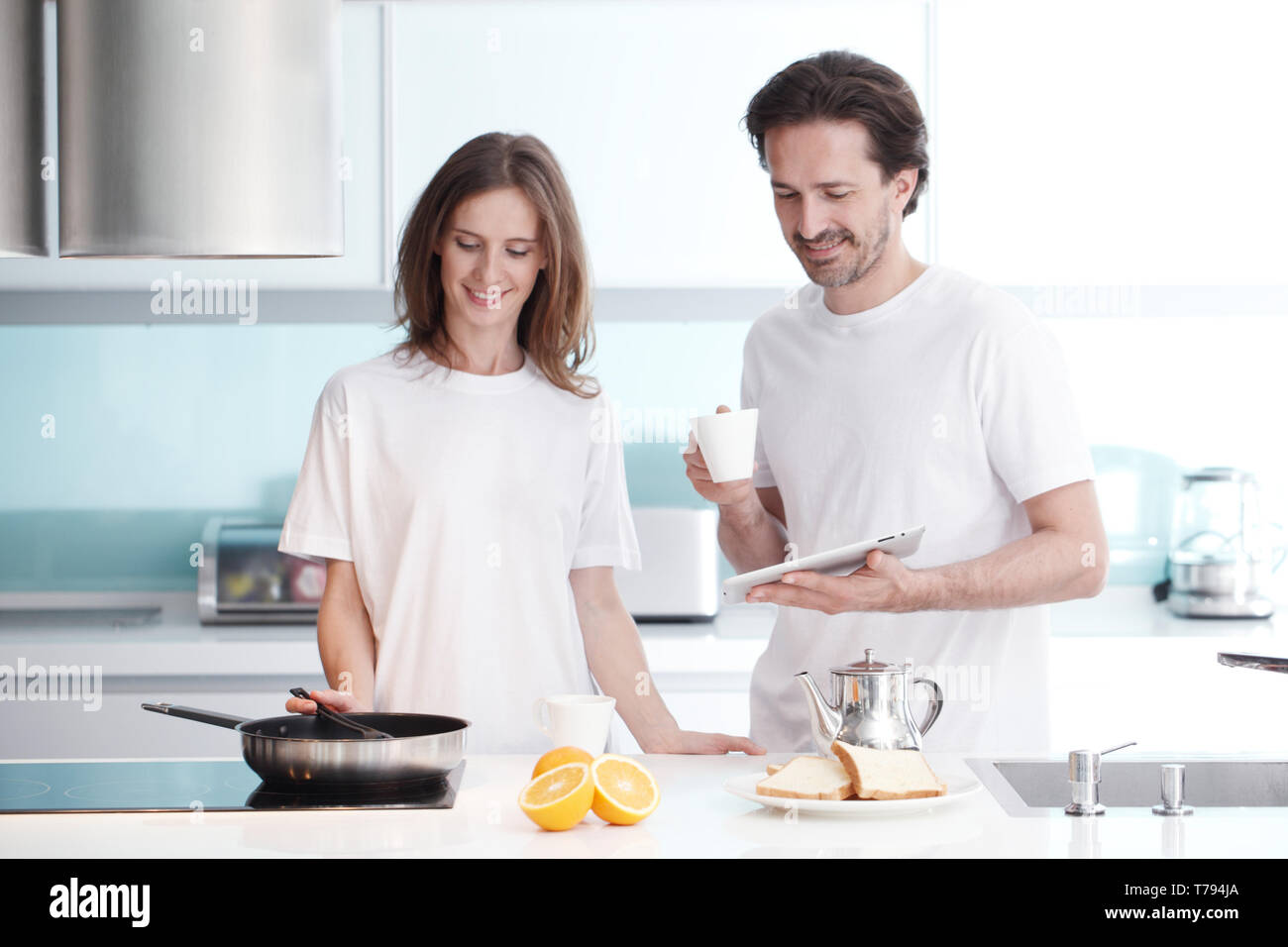 Happy couple cooking breakfast together in the kitchen Stock Photo - Alamy