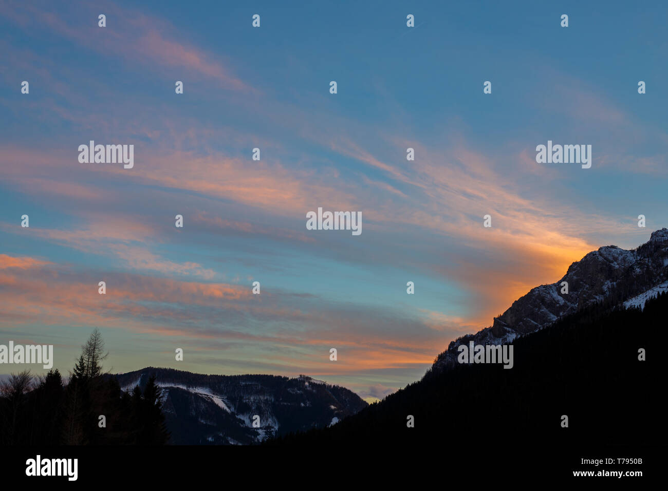 colorful sunset with glowing clouds above mountain tops in the austrian ...