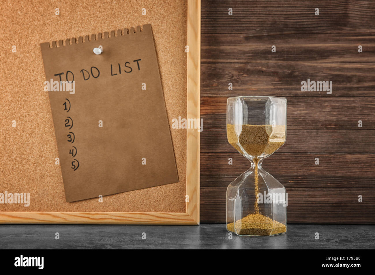 Hourglass on table and sheet of paper with to-do list on board. Time ...