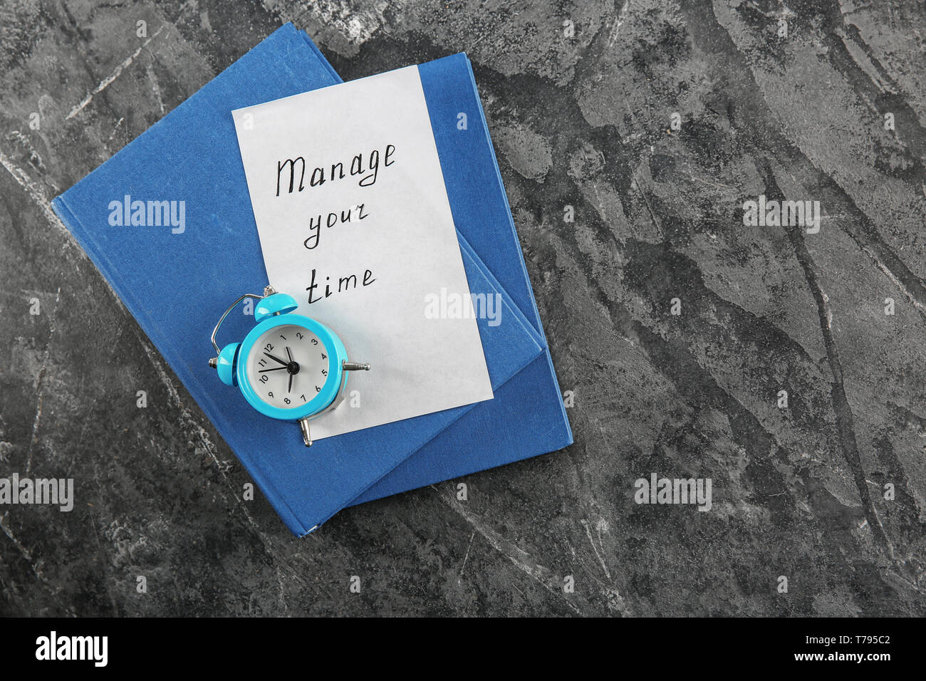 Alarm clock with books on grey textured background. Time management ...