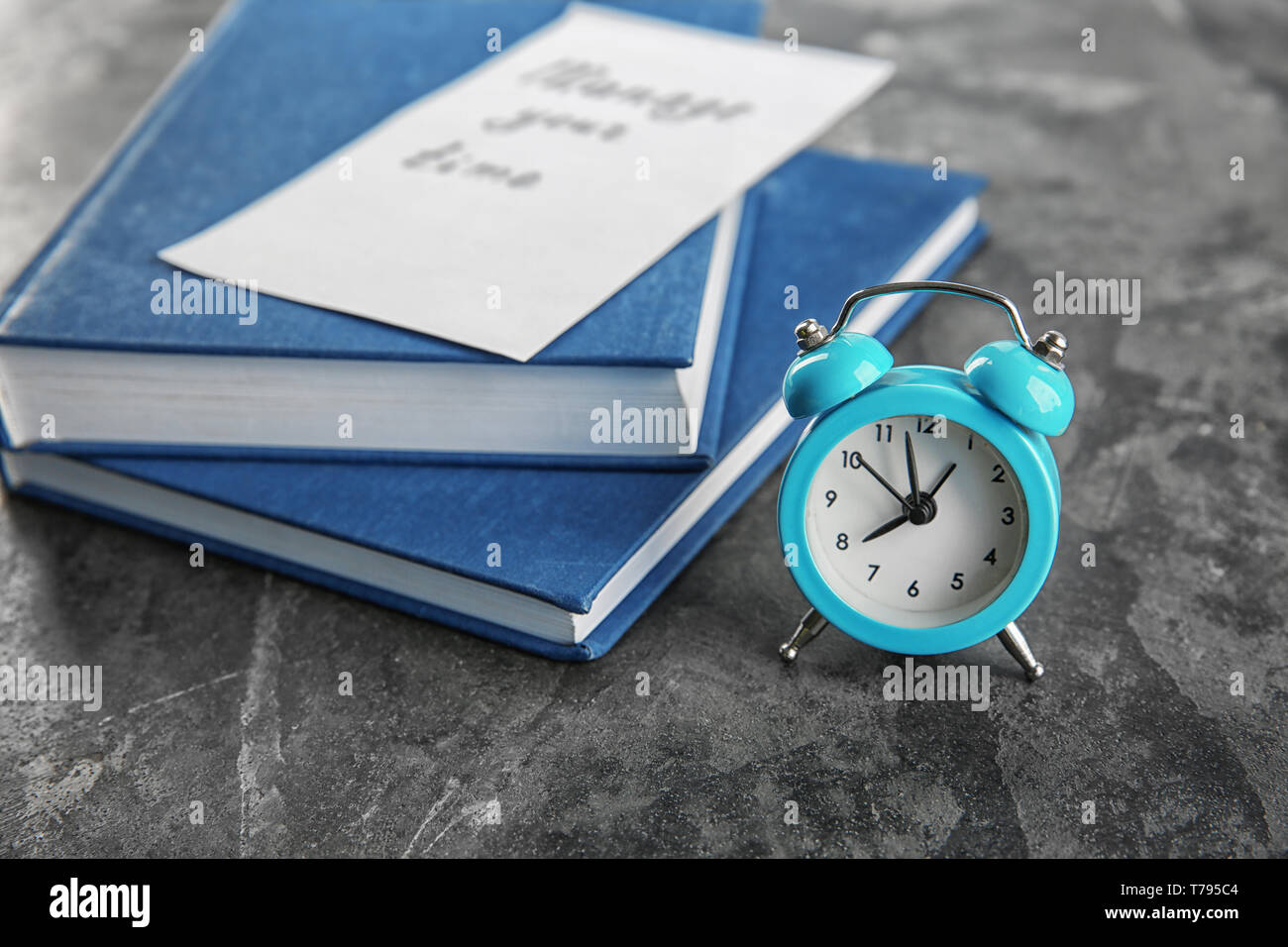 Alarm clock with books on grey textured background. Time management ...