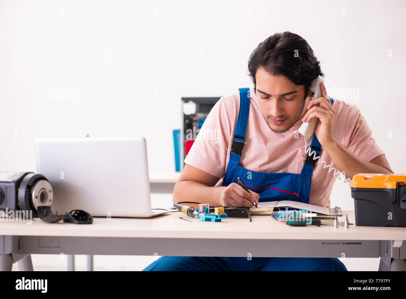Young male contractor repairing computer Stock Photo - Alamy