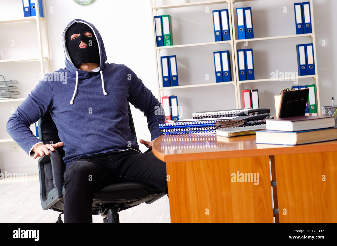 Male thief in balaclava in the office Stock Photo - Alamy