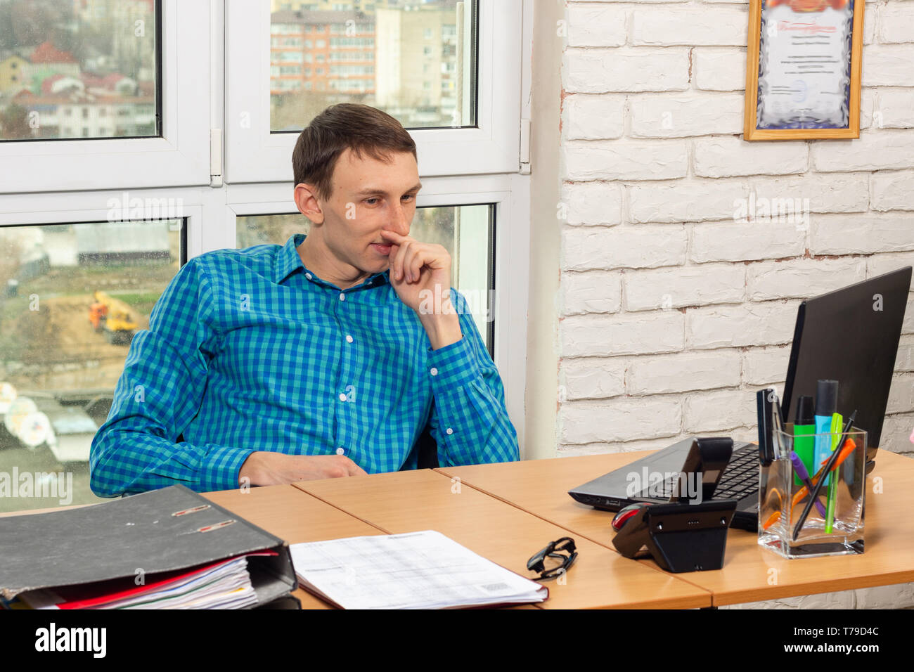 Young office worker thinking in the workplace Stock Photo - Alamy