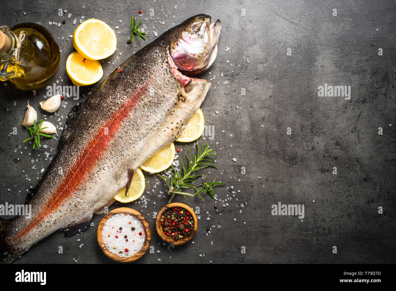 Raw salmon fish whole with ingredients for cookings on black Stock ...