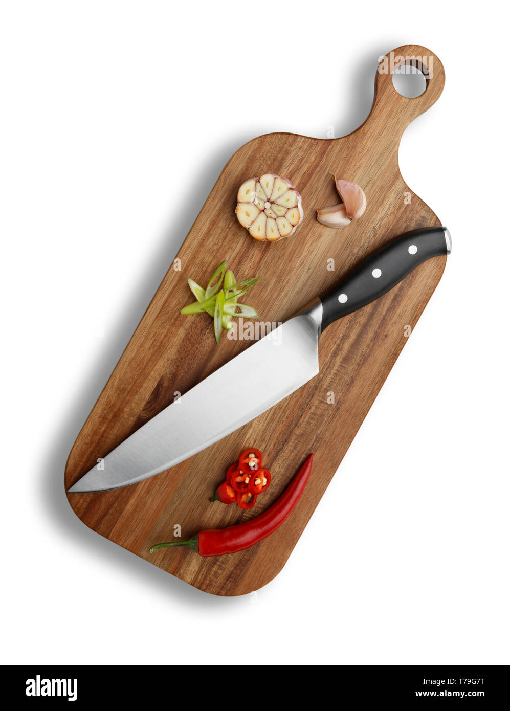 chilli, garlic, spring onion and knife a wooden chopping board on a ...