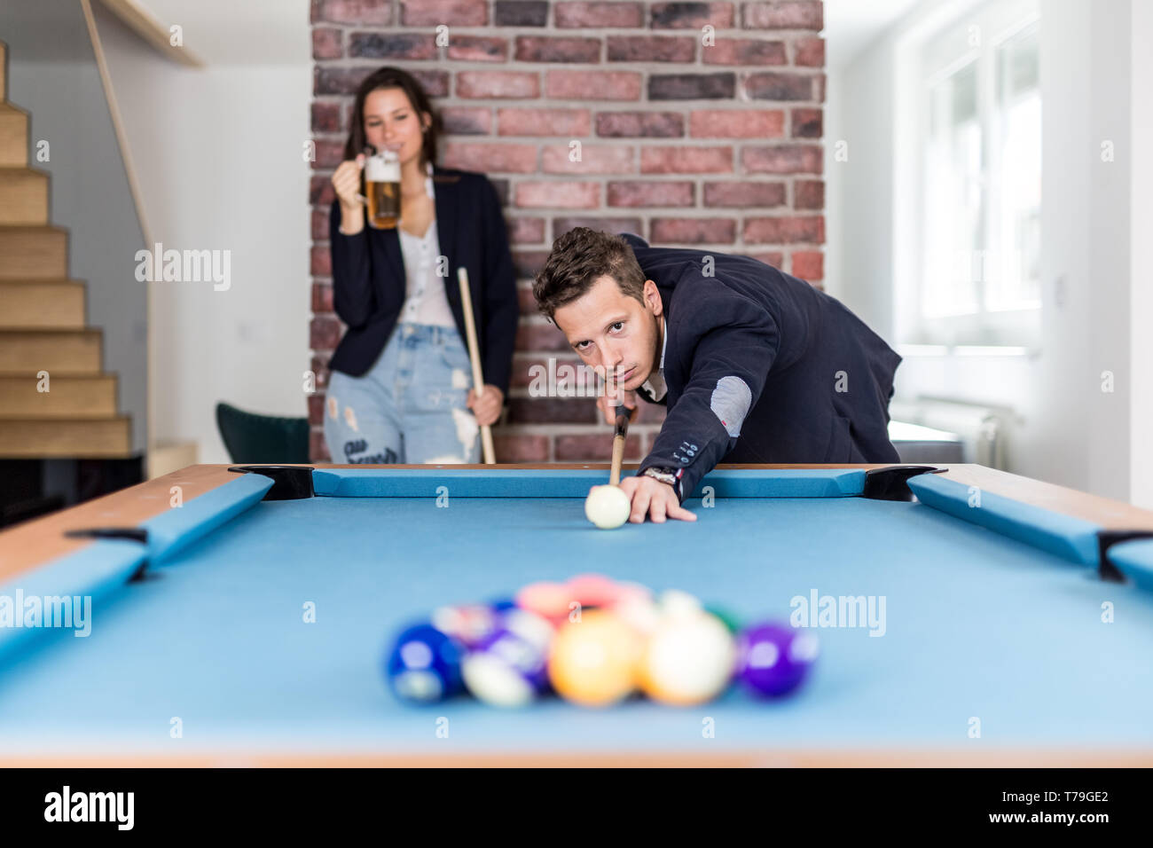 Beautiful fashionable couple playing pool table billiard game in office ...