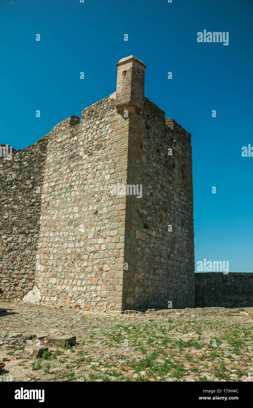 Stone solid walls and square watchtower in front of cobblestone square ...