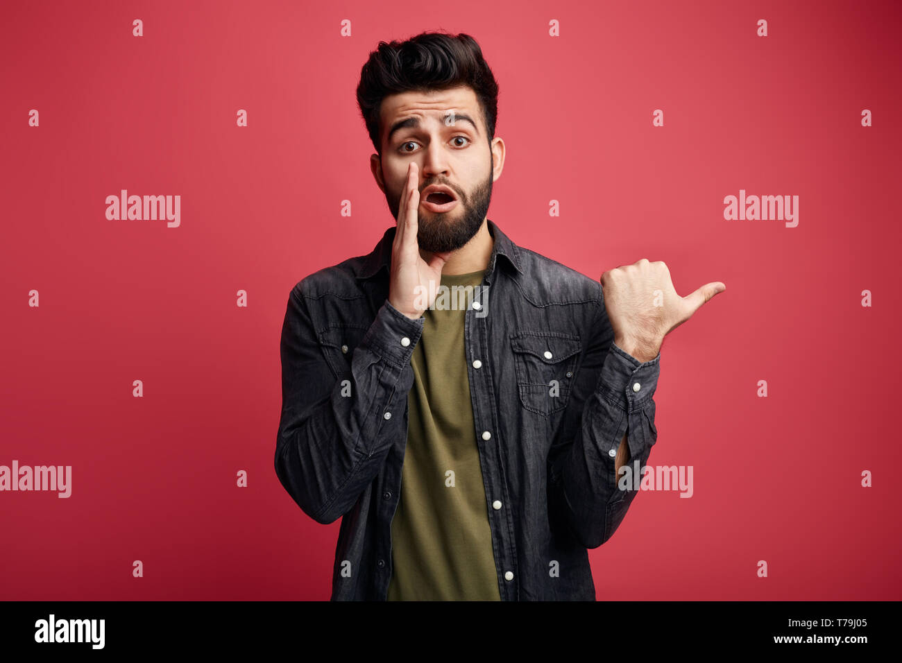 awesome guy with a palm on his mouth, gossiping, whispering something ...