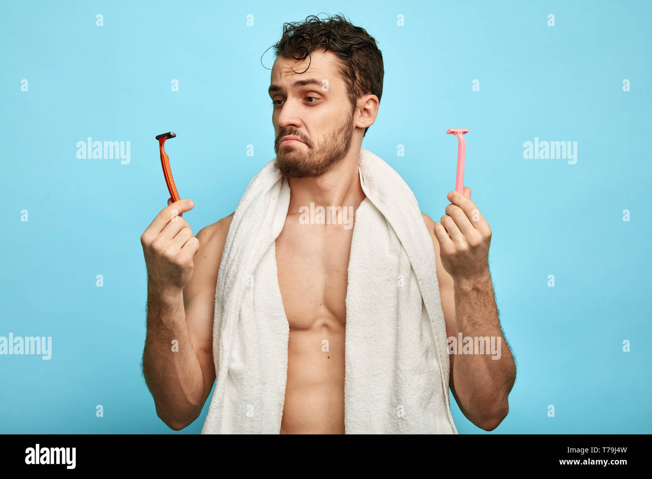 emotional confused muscular man with a towel on his neck holding two ...