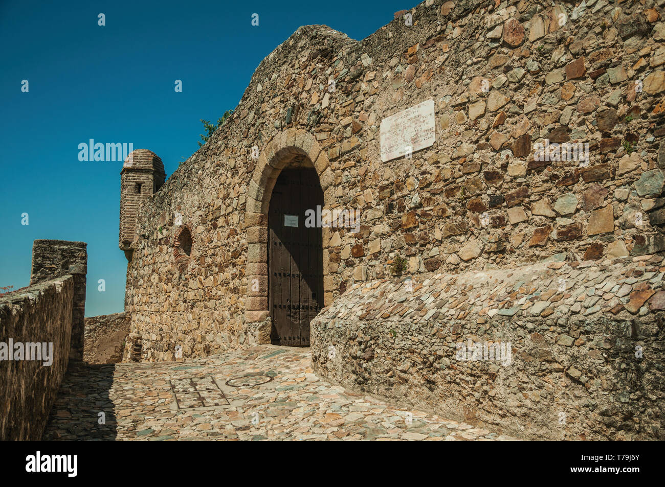 Close-up of gateway in the stone outer wall with wooden door and ...