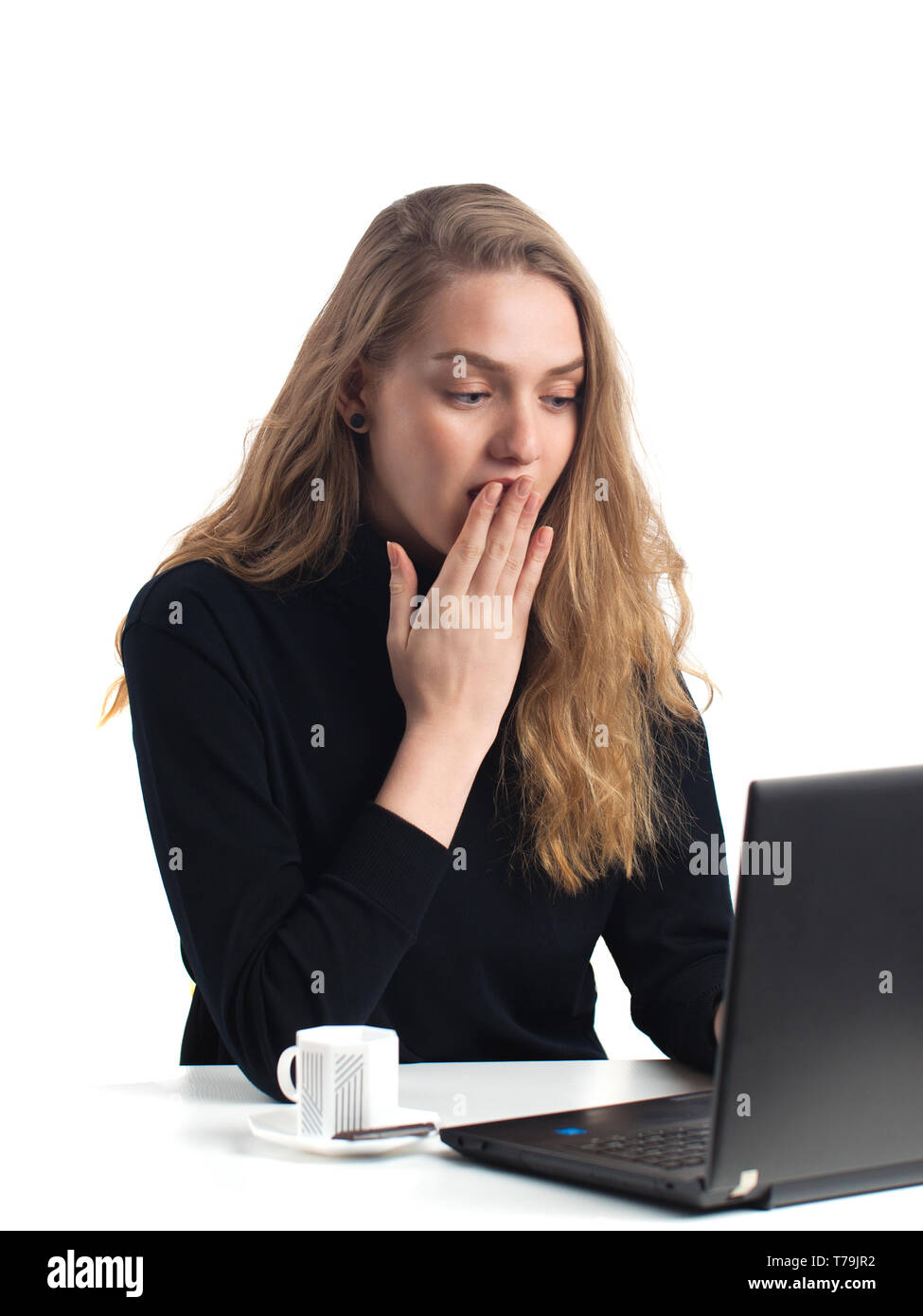Portrait of young girl (woman) sitting in front of laptop and typing on ...
