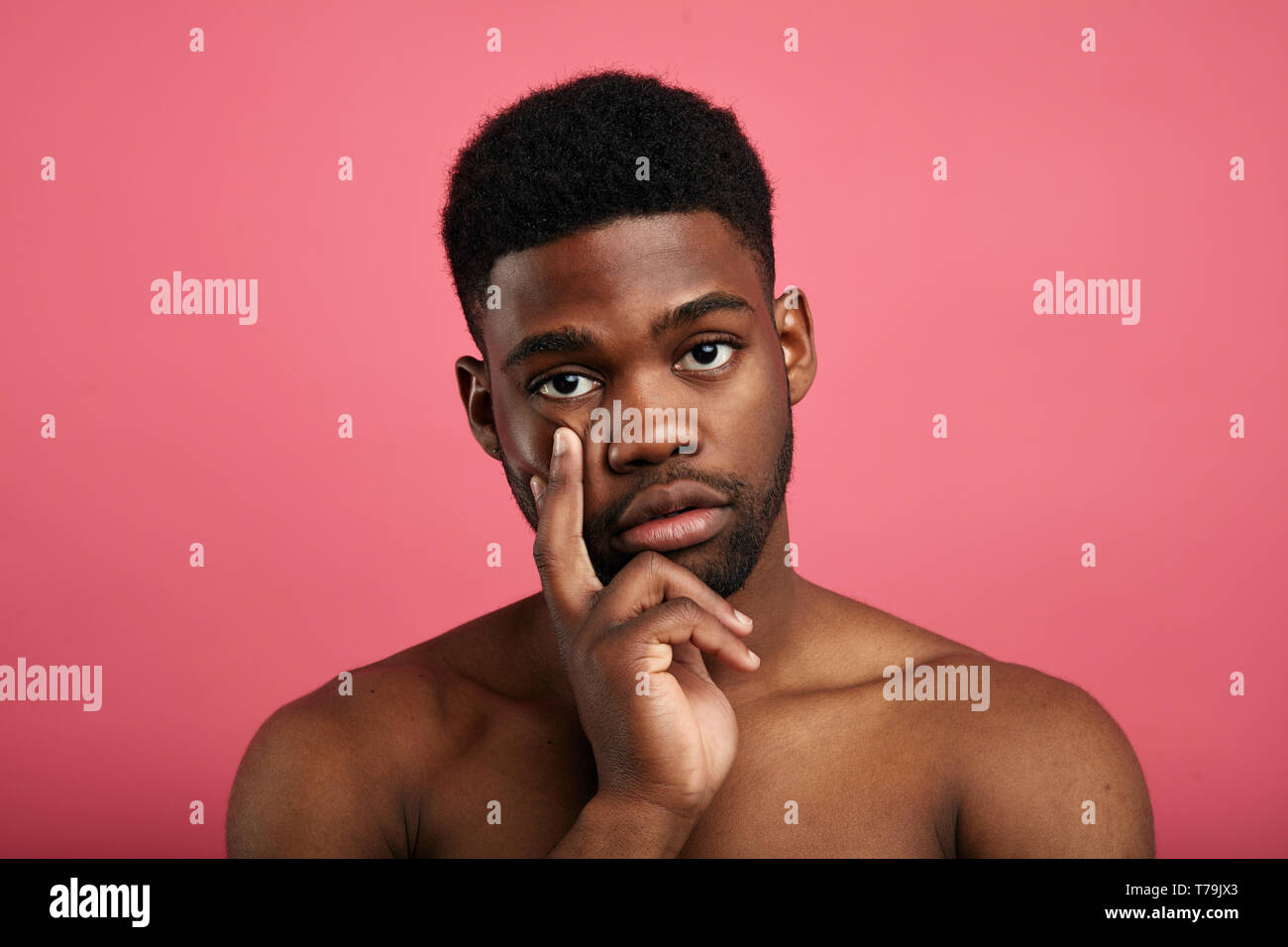 serious young man having concentrated thoughtful expression, keeping ...