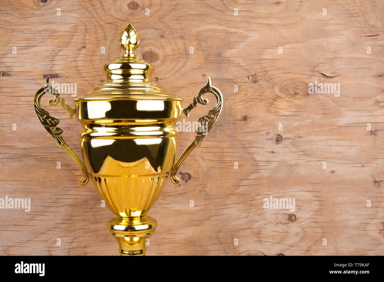Blank gold cup trophy against the wooden background Stock Photo - Alamy