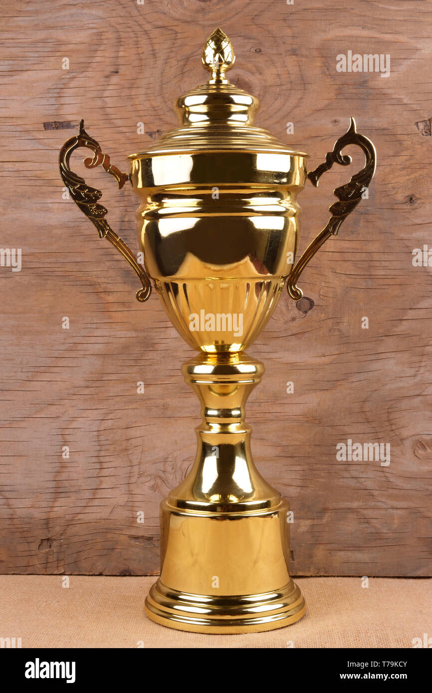 Blank gold cup trophy against the wooden background Stock Photo - Alamy