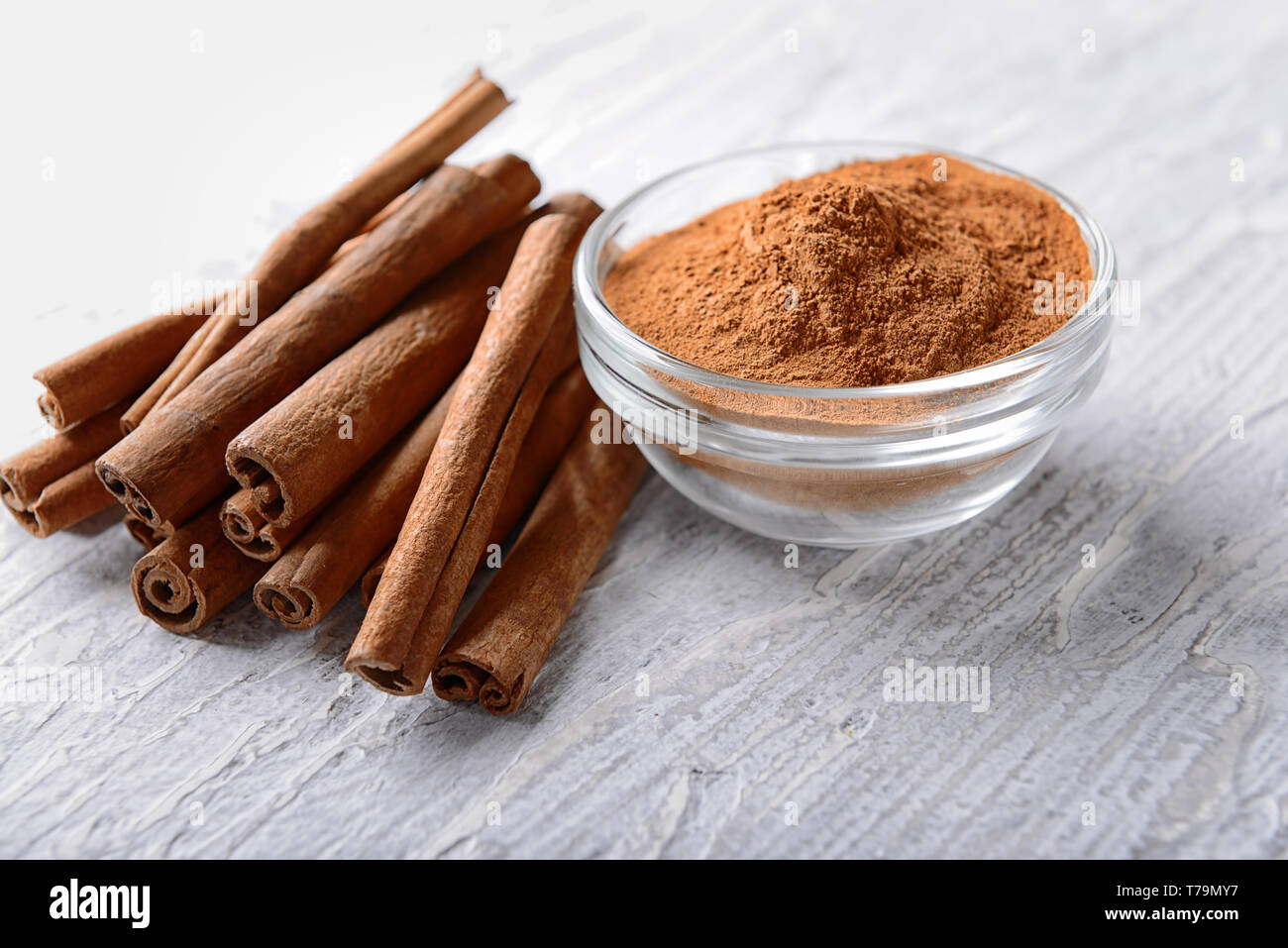 Cinnamon sticks and powder on wooden background Stock Photo - Alamy
