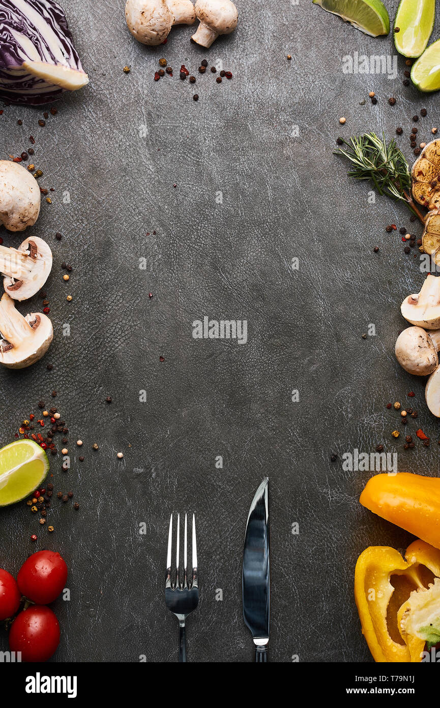 food background. raw vegetable ingredients with cutlery around grey ...