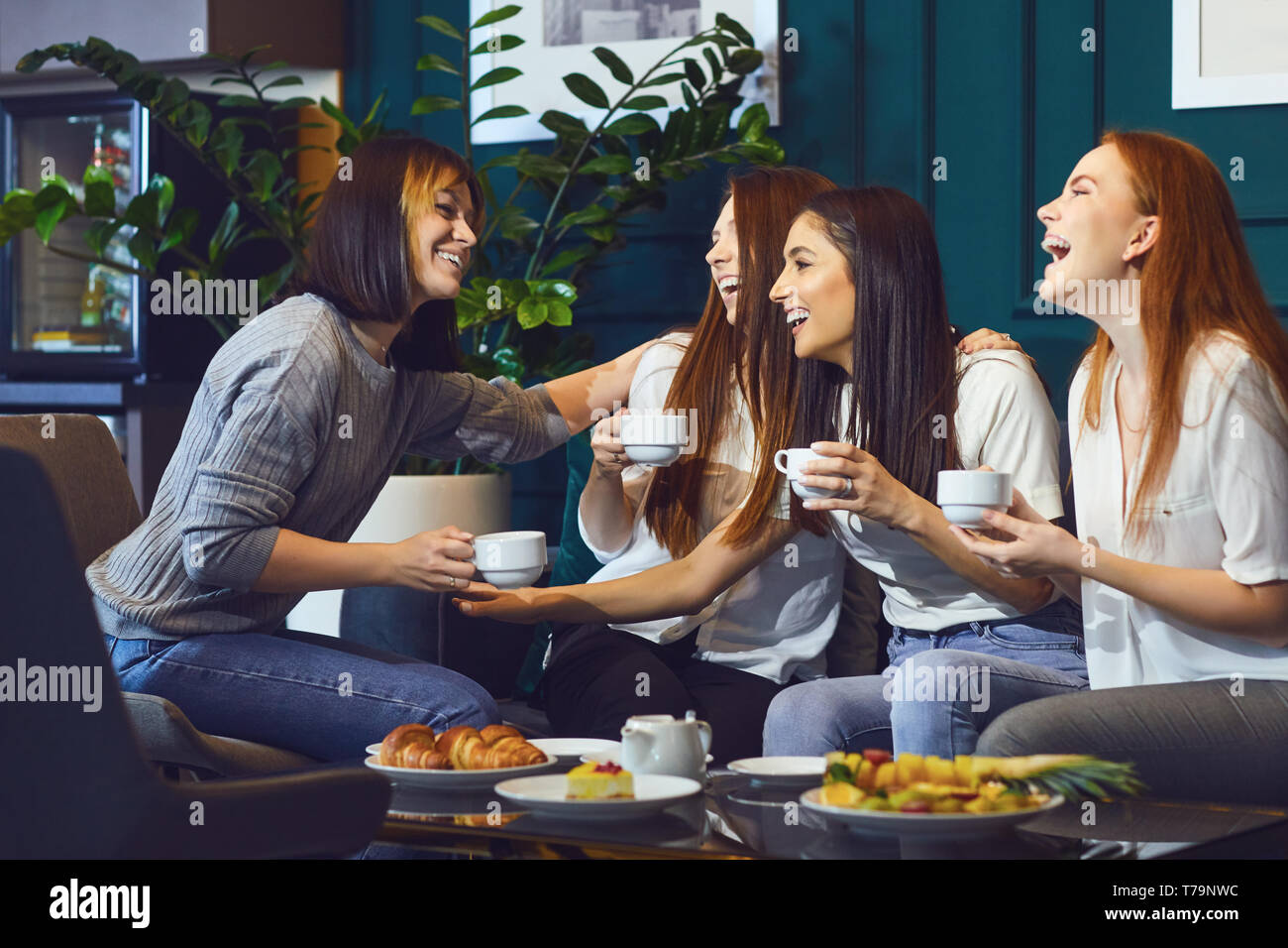 Young laughing women having tea party Stock Photo - Alamy