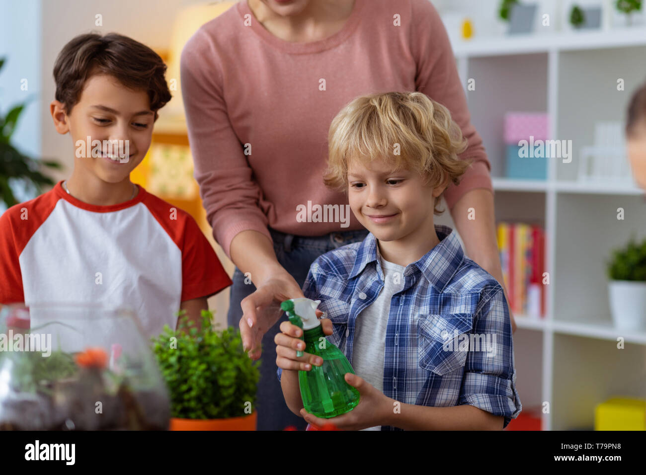 Holding water diffuser. Cute blonde pupil holding water diffuser while ...