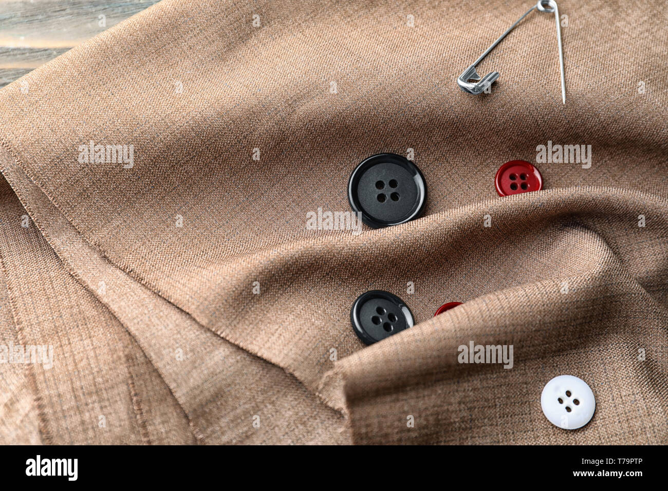 Safety pin and buttons on fabric Stock Photo - Alamy