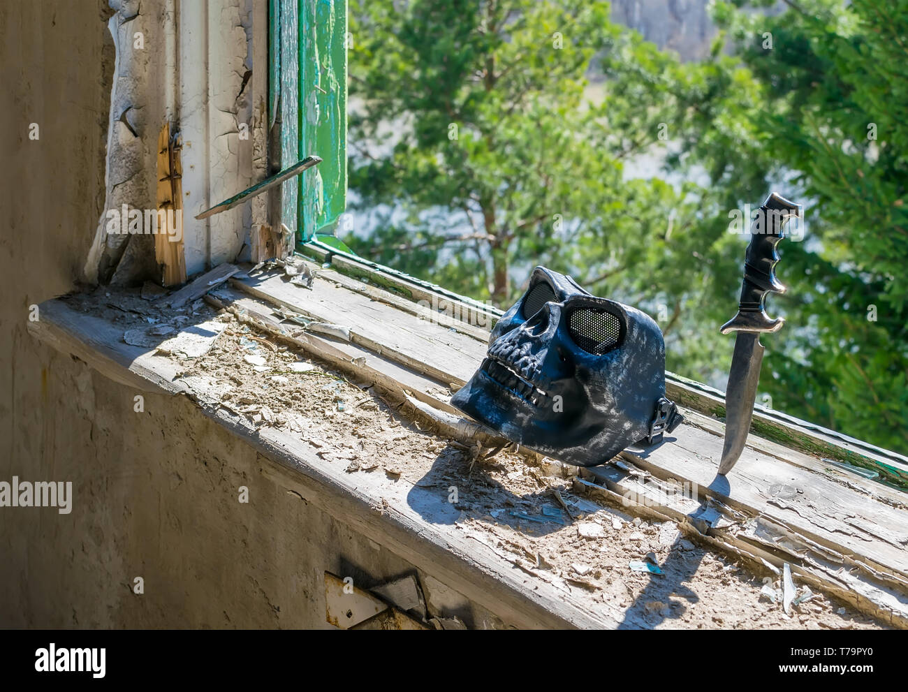 a terrible mask in the form of a skull and an old combat knife stuck in ...