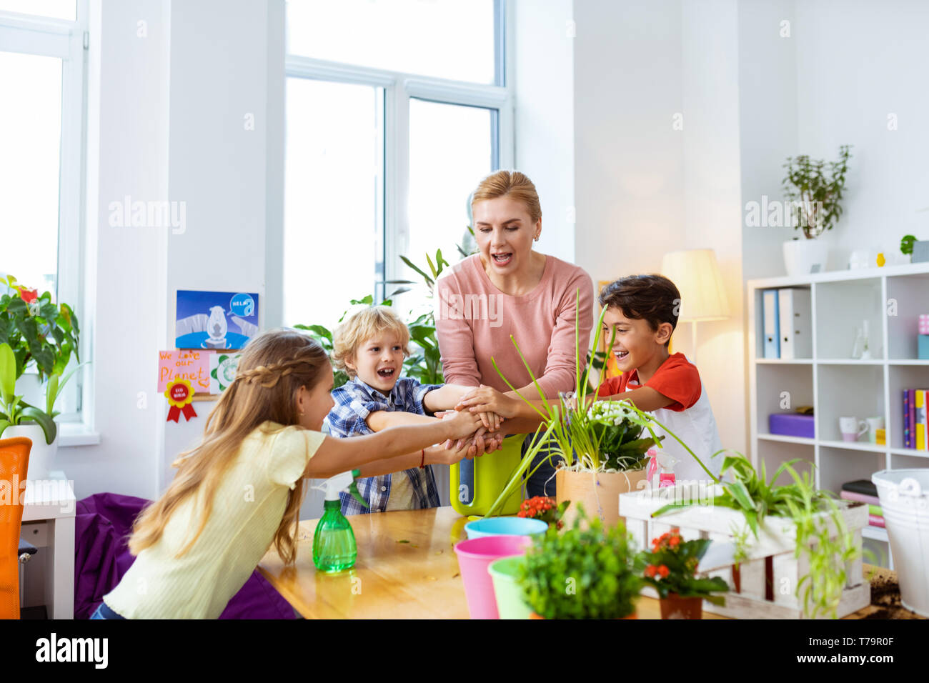 Hands together. Teacher and three pupils holding their hands together ...