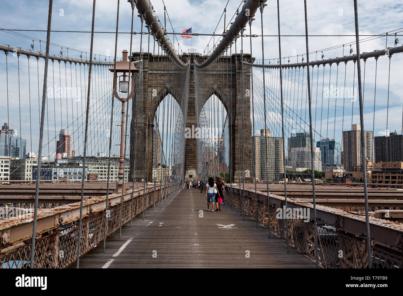 People are walking across the Brooklyn Bridge, a hybrid cable-stayed ...
