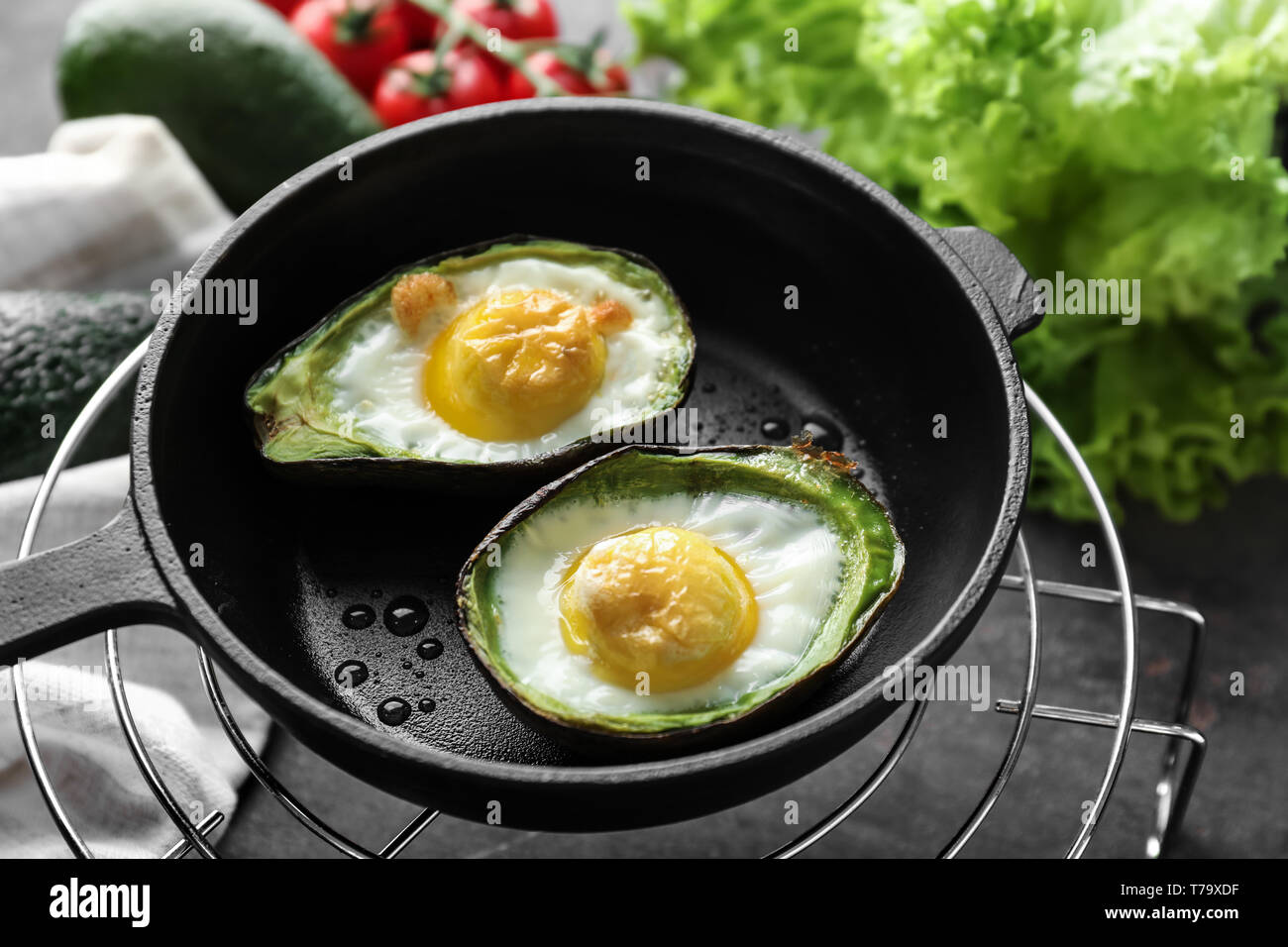 Baked avocado with eggs in frying pan Stock Photo - Alamy