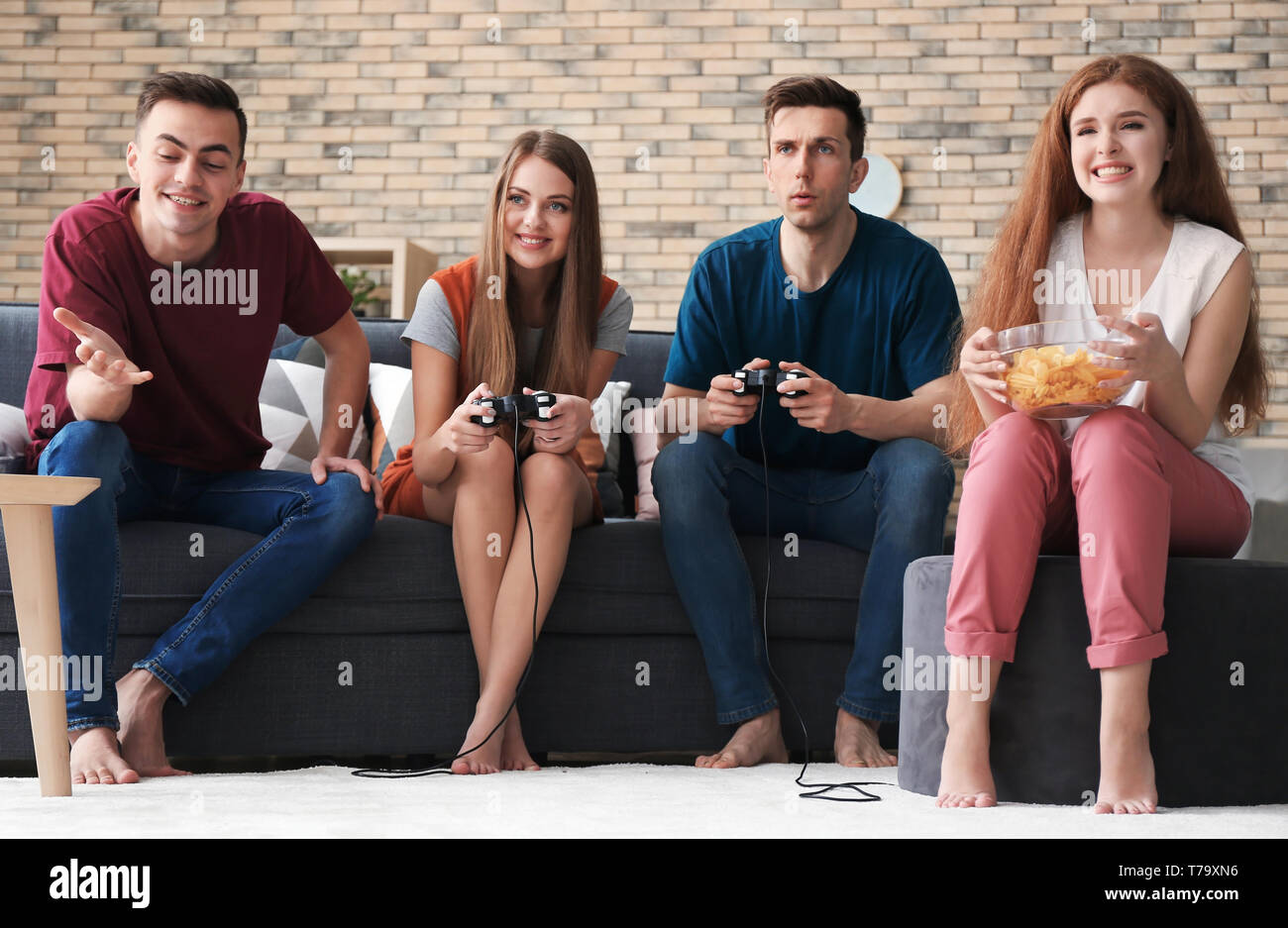 Young people playing video games at home Stock Photo - Alamy