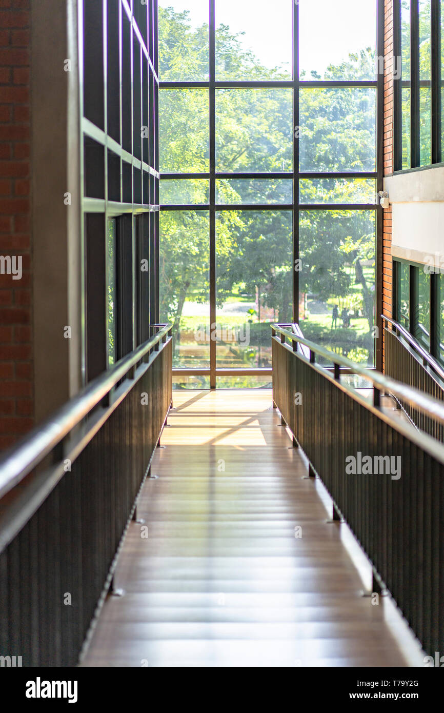 wooden slope walkway in the library with the window light from outside ...