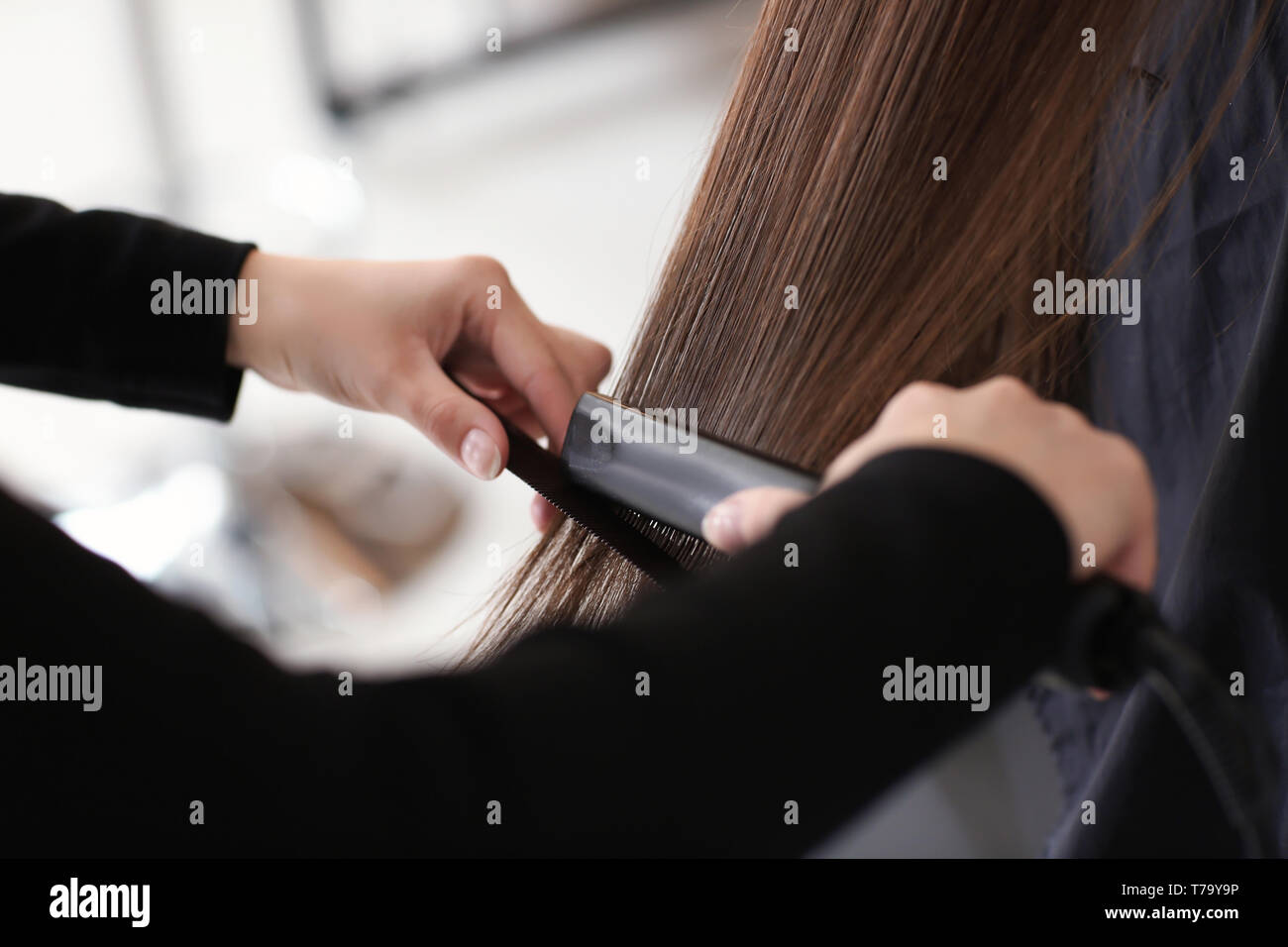 Professional hairdresser straightening client's hair in salon Stock ...