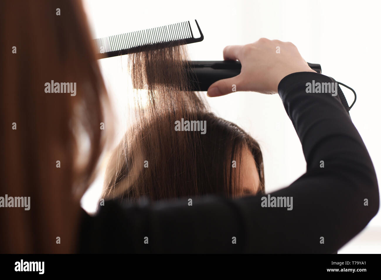 Professional hairdresser straightening client's hair in salon Stock ...