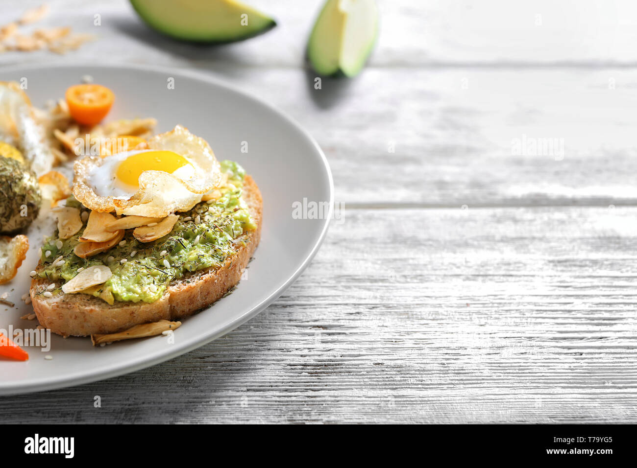 Delicious toast with avocado on plate Stock Photo - Alamy