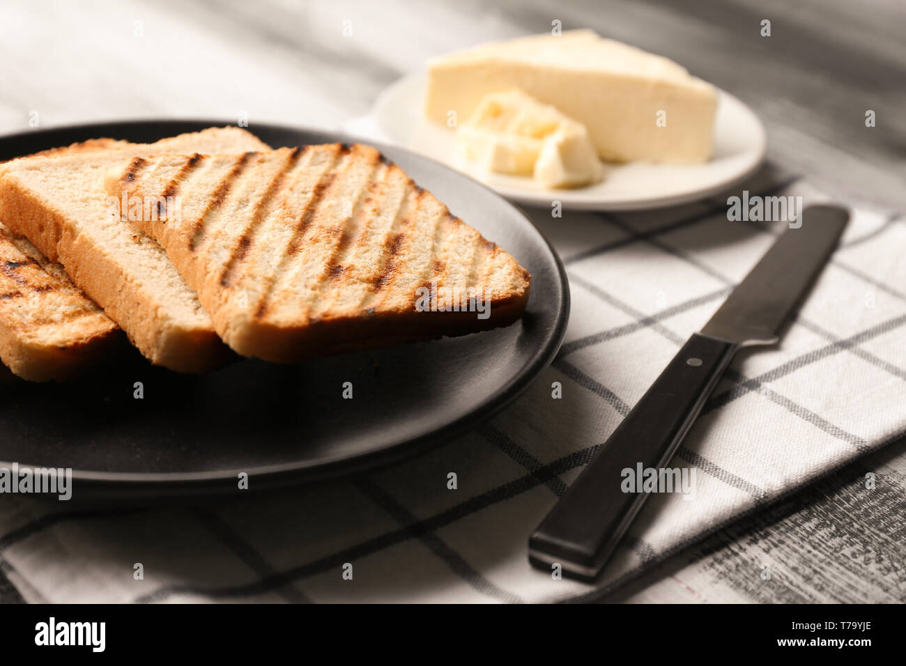 Plate with toasted bread on table Stock Photo - Alamy