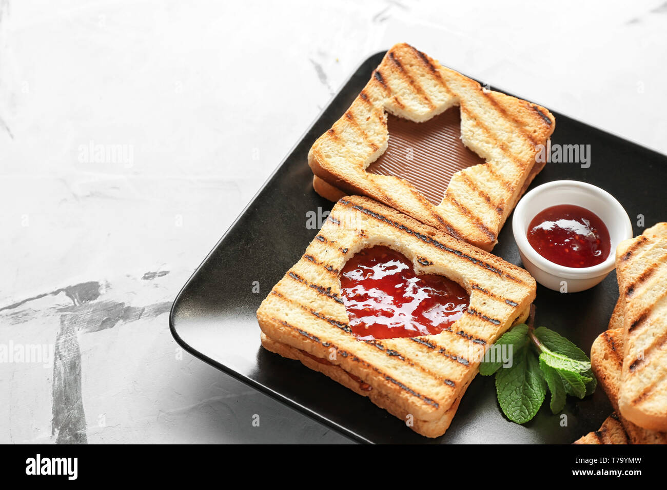 Delicious toasts with jam and chocolate paste on plate Stock Photo - Alamy