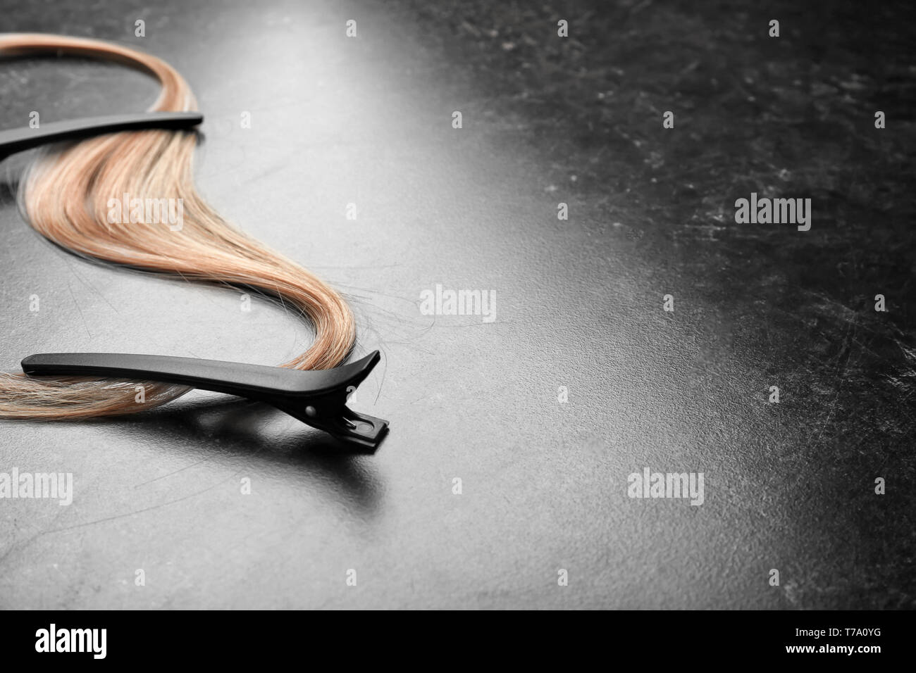 Clips with strand of blonde hair on grey background Stock Photo - Alamy