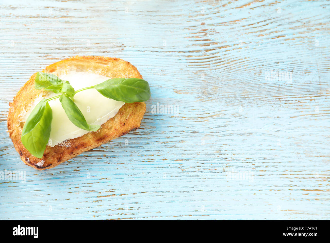 Toasted bread with cream cheese and basil on table Stock Photo - Alamy