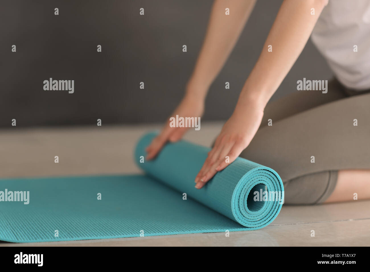 Young woman with yoga mat indoors Stock Photo - Alamy