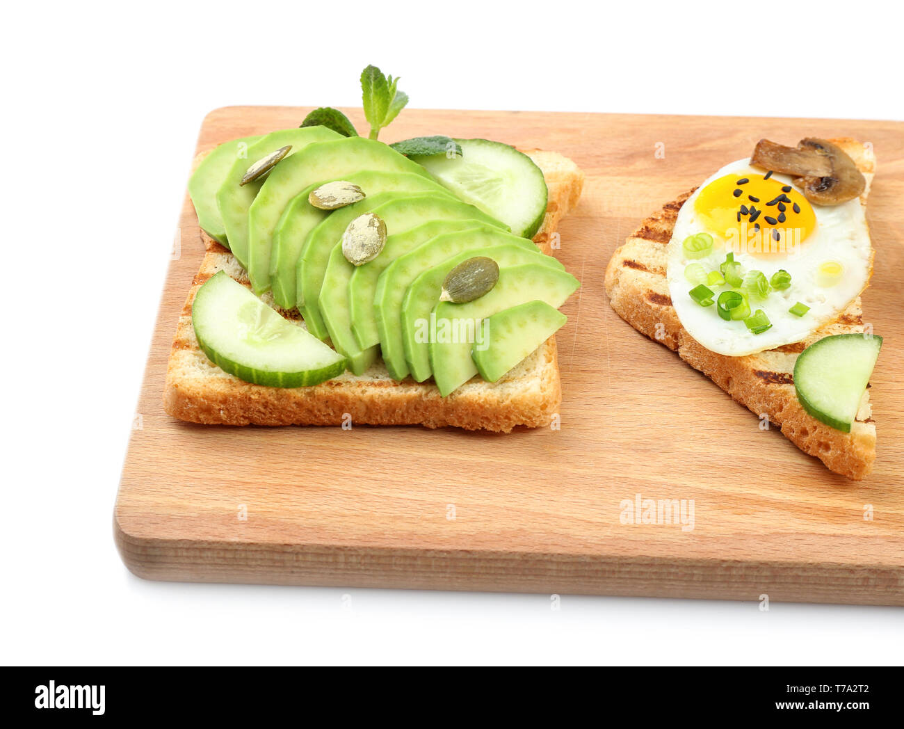 Wooden board with different delicious toasts on white background Stock ...