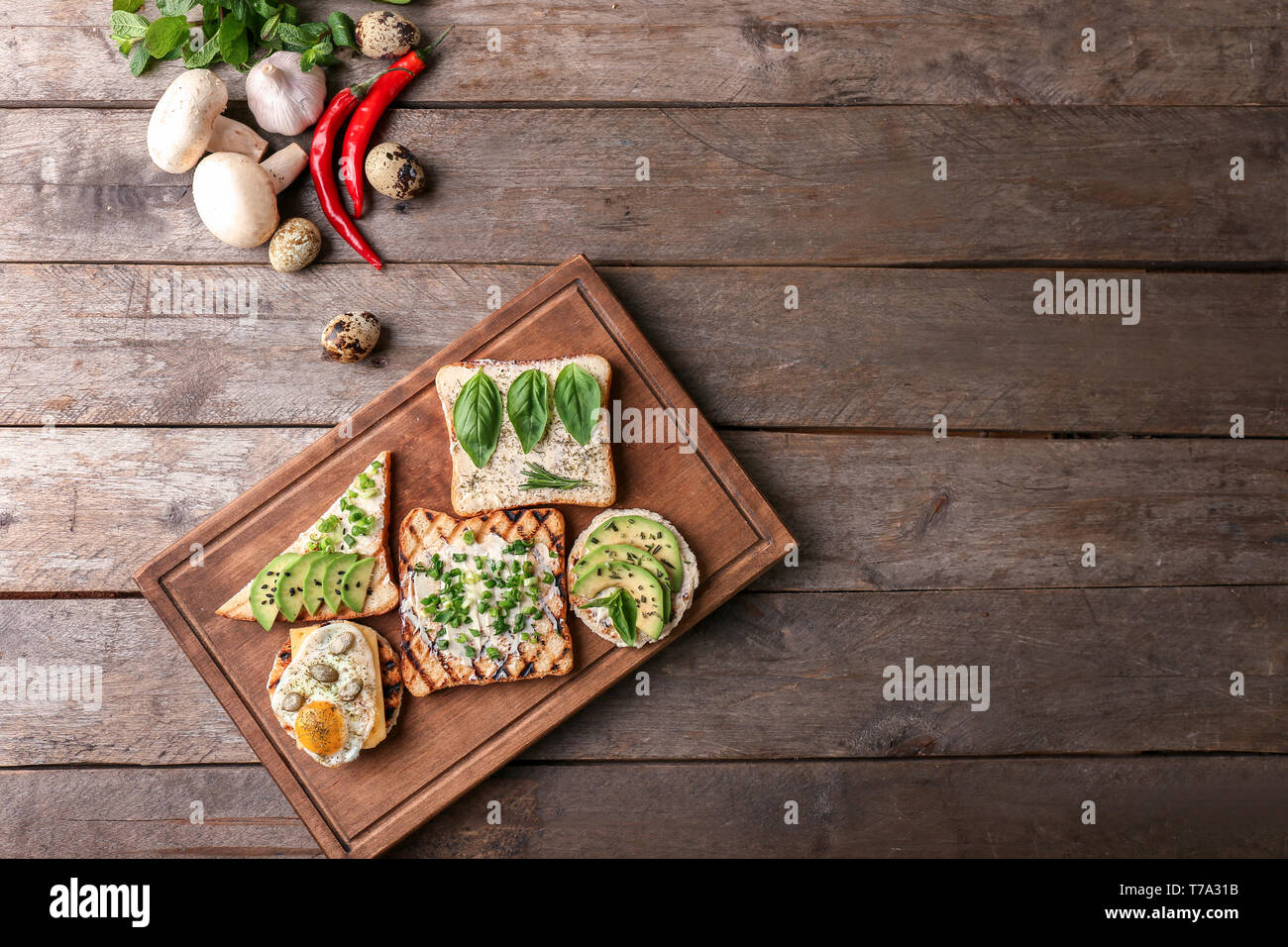 Different delicious toasts on wooden board Stock Photo - Alamy